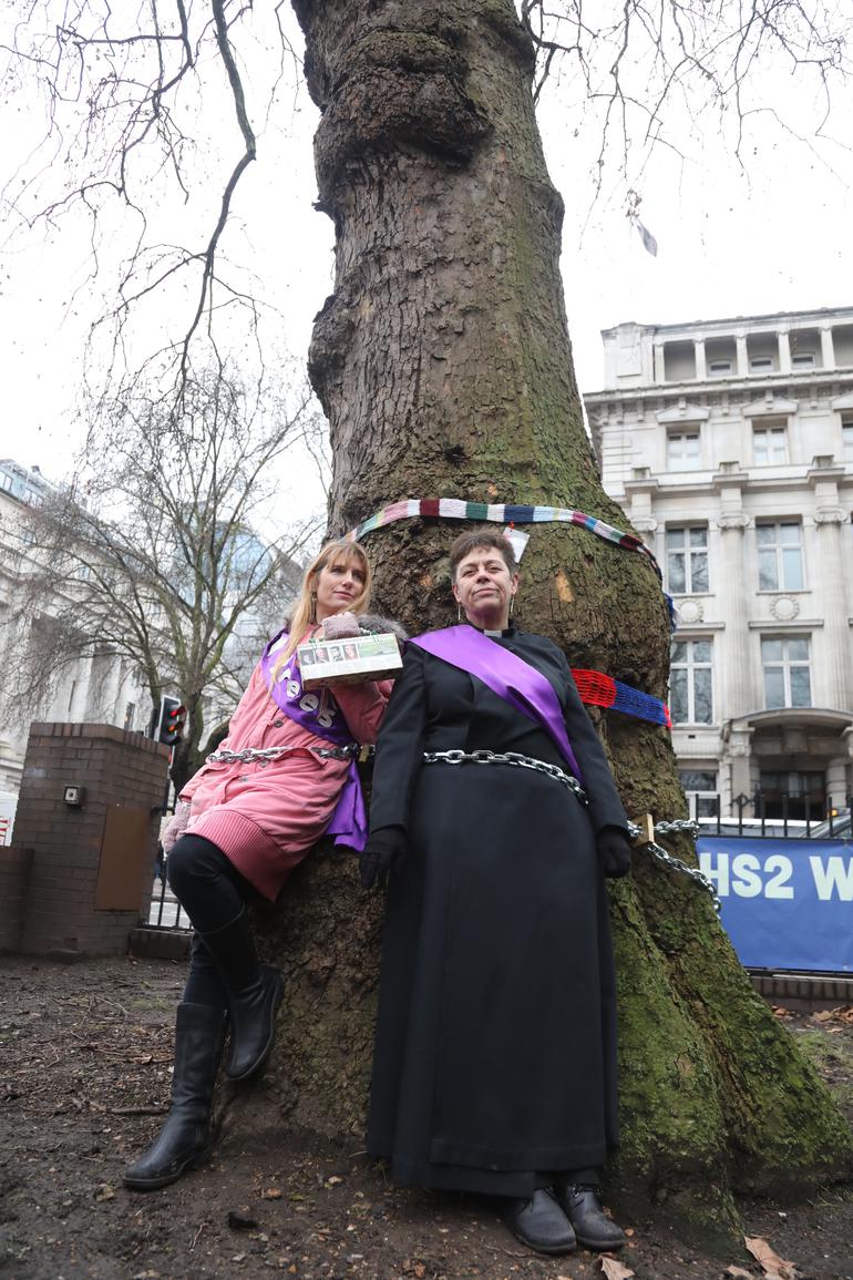 London vicar chains herself to tree in train line protest